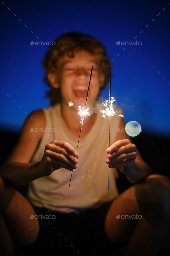 Glad boy with glowing Bengal lights Stock Photo by ADDICTIVE_STOCK