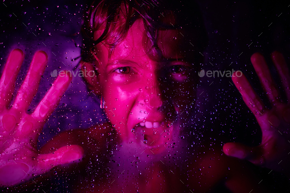 Crop angry boy screaming behind wet glass wall Stock Photo by ADDICTIVE ...