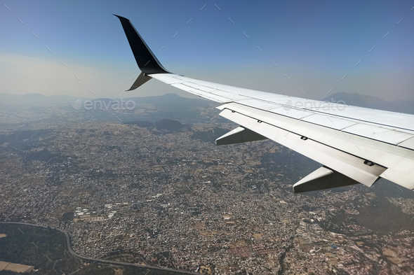 View through airplane window of commercial jet plane wing flying high ...