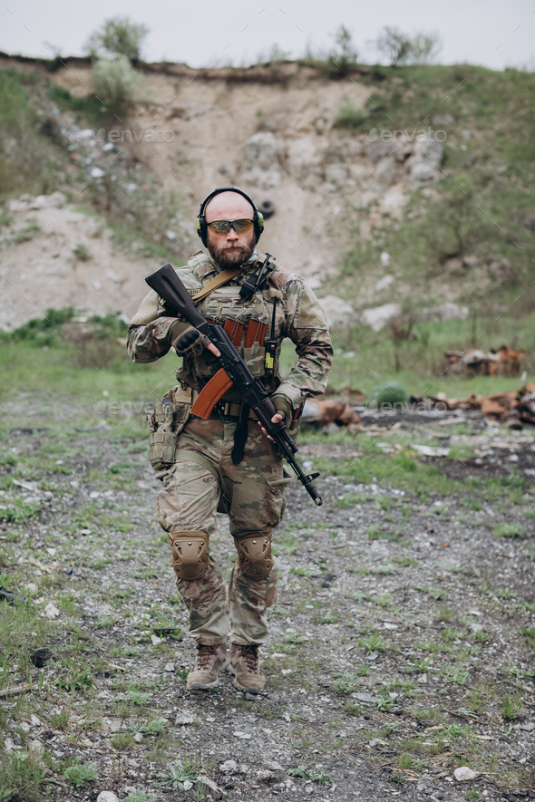 Portrait of Ukrainian soldier holding rifle Stock Photo by dmytros9