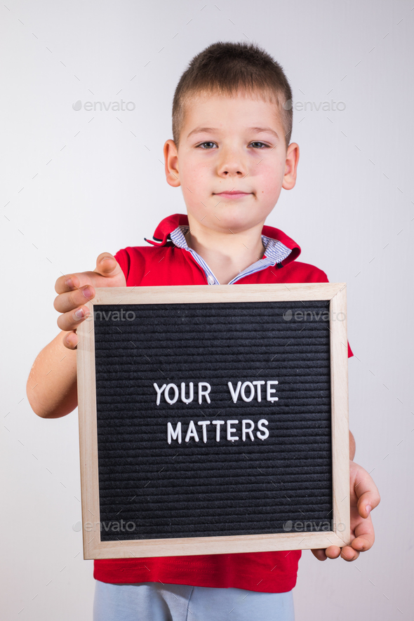 kid boy holding letter board with text Your Vote Matters on white ...