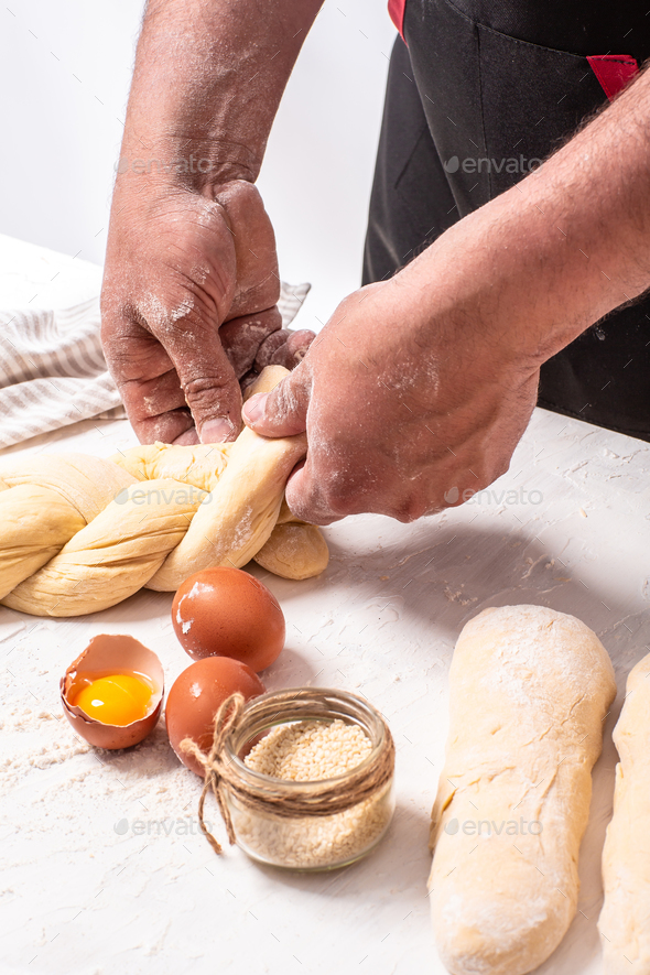 Baker's hands weave bread dough. Israeli authentic food. mixing powder ...