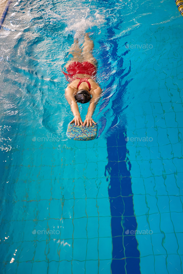 Female athlete in swimsuit practicing flutter kicks in water Stock ...