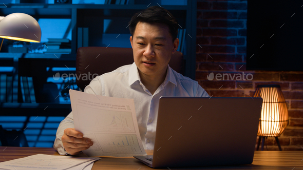 Focused middle-aged Korean businessman working online project smiling ...