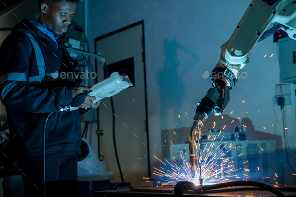 Engineer inspection control a robot arm welding machine. Stock Photo by ...