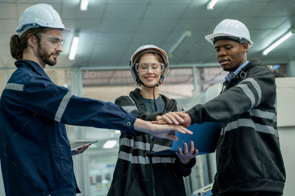 Engineering team are standing and join hands to celebrate the success ...