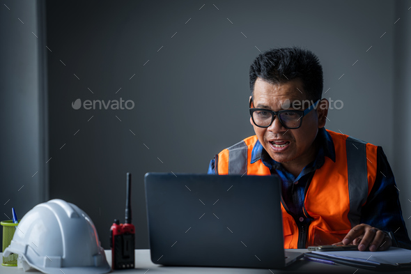 Engineer working with laptop computer in builders at construction site ...