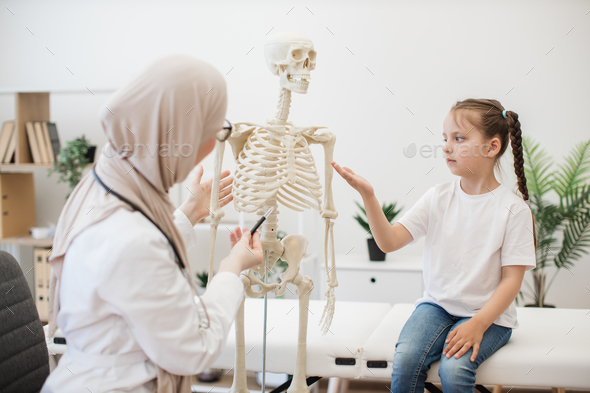 GP consulting tween kid about human body by anatomical model Stock ...