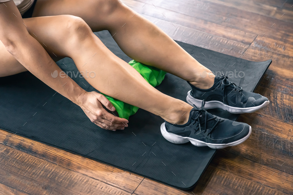 Sport woman using foam roller for muscle and fascia stretching foot ...