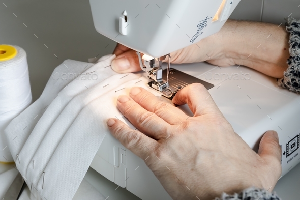 Old woman sewing face mask with the help of a sewing machine Stock ...