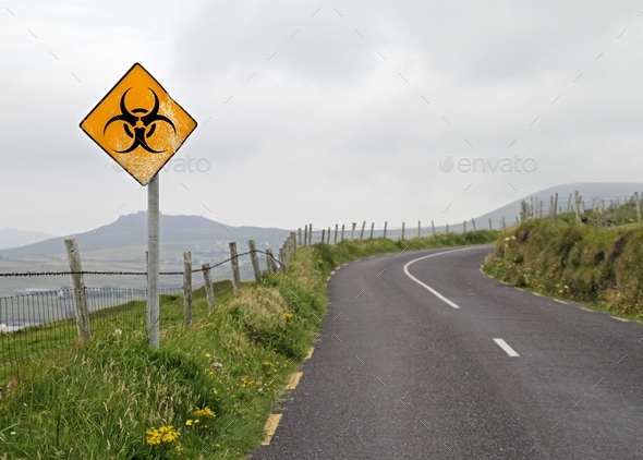 Road sign with bio hazard symbol in front of a curve Stock Photo by ...