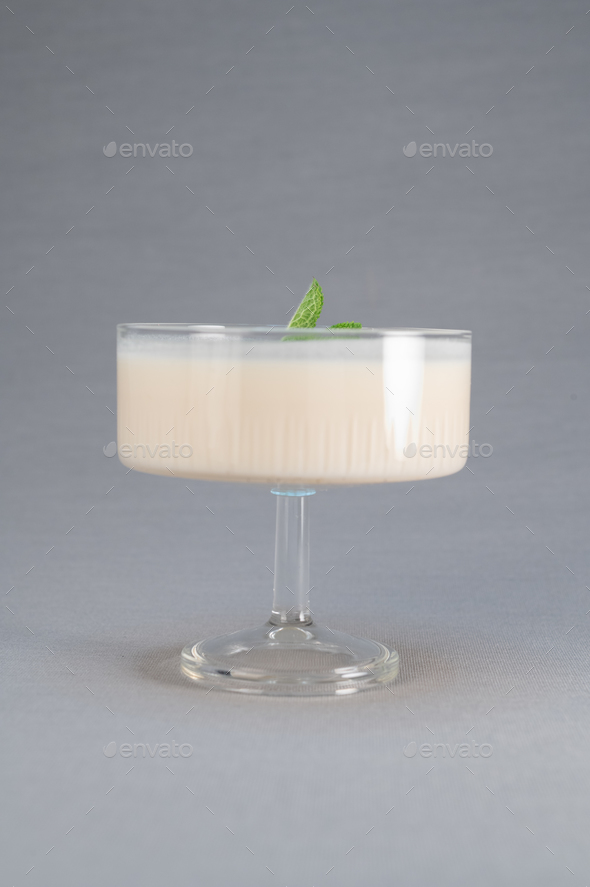 Glass of White Rabbit Cocktail with vanilla cream, gin and lemon curd ...