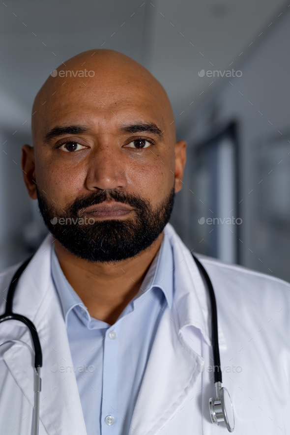 Portrait of biracial male doctor wearing lab coat and stethoscope in ...