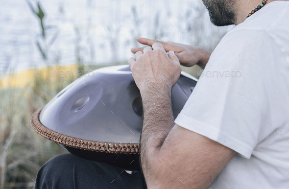 Close-up and side view of an unrecognizable man playing a traditional ...