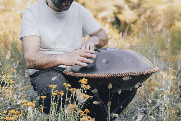side view of the hands of an unrecognizable man playing handpan in ...