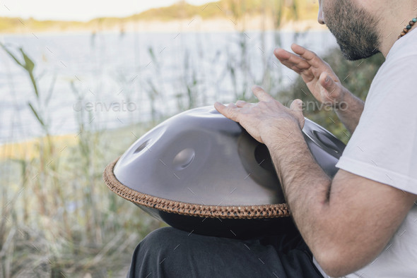 Close-up and side view of an unrecognizable man playing a traditional ...