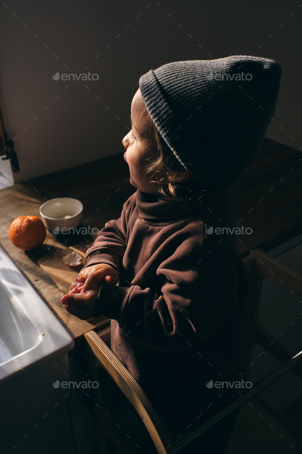 Adorable calm little boy standing near table in kitchen in sunli Stock ...
