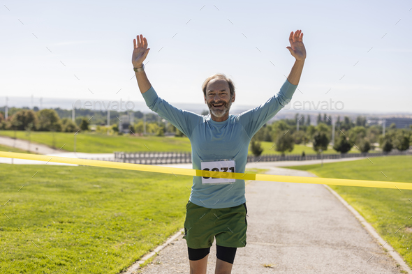 Happy senior running across the finish line - Mature man running ...