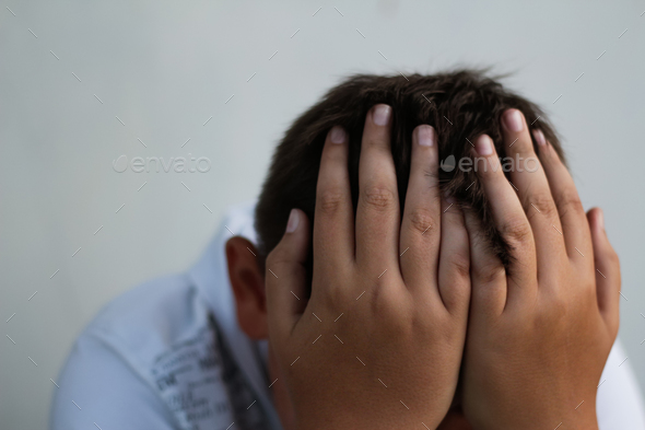 sad little boy sitting. Child cry and hiding his face. Kid alone ...