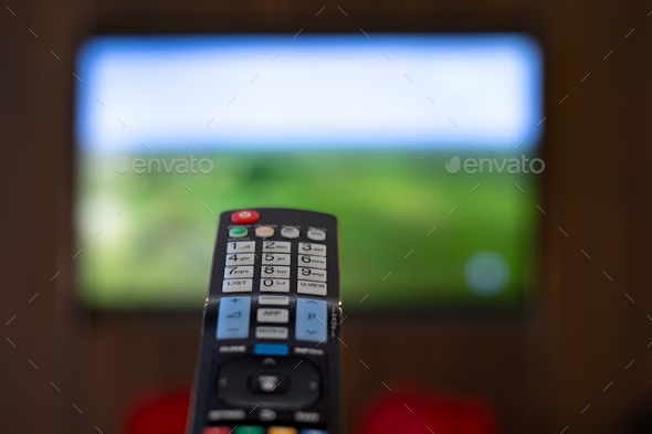 TV remote control pointing towards the TV Stock Photo by eelinstudio