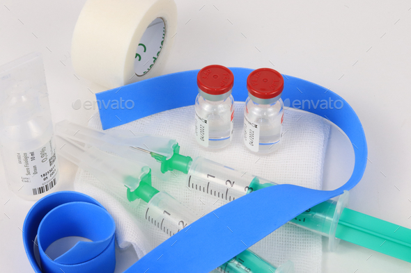Shot of vaccine containers, a tape, gloves, syringe and other medical ...