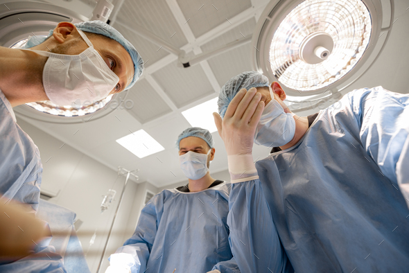 Scary surgeons look at the place of surgical interventio Stock Photo by ...