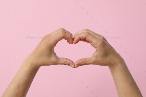 Female hands make a heart sign with fingers on a pink background Stock ...