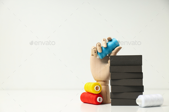 Tower of black wooden blocks and threads on white background, place for ...