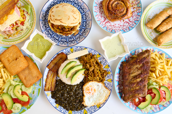 Table with typical Venezuelan food. Creole pavilion, arepas, fried pork ...