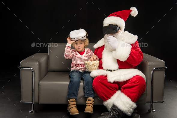 Santa Claus with child eating popcorn and wearing virtual reality ...