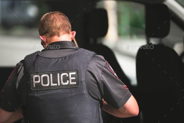 Back view of police officer wearing uniform Stock Photo by wirestock