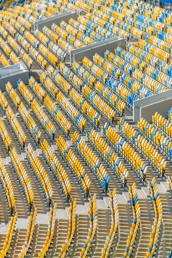 rows of yellow and blue stadium seats and stadium stairs Stock Photo by ...