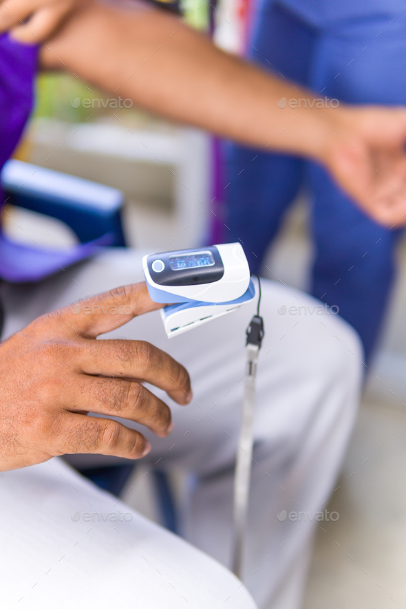 Patient's hand with a pulse oximeter to measure pulse rate and oxygen ...