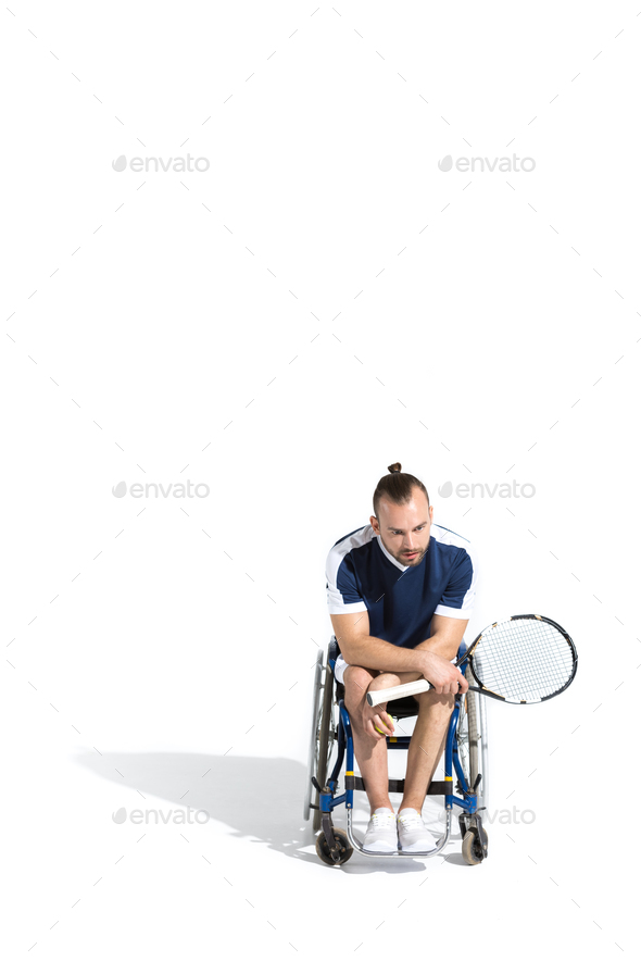 Disabled young man sitting in wheelchair and holding tennis racquet ...