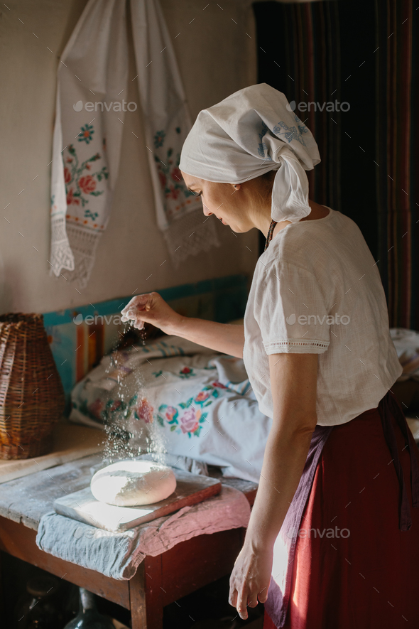 The process of traditional baking of bread at home. A woman in national ...