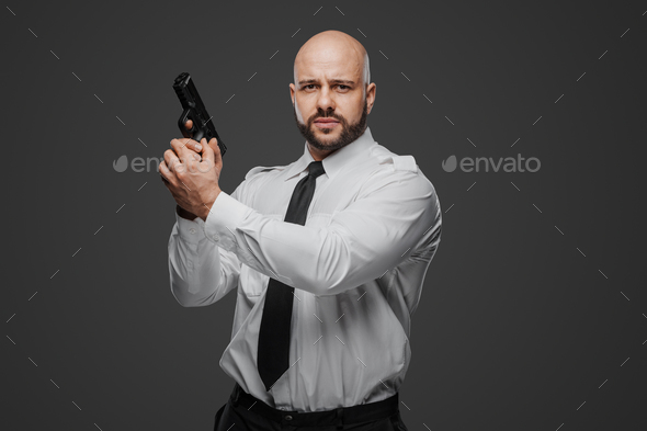 Bald man in white shirt and tie poses with pistol Stock Photo by fxquadro
