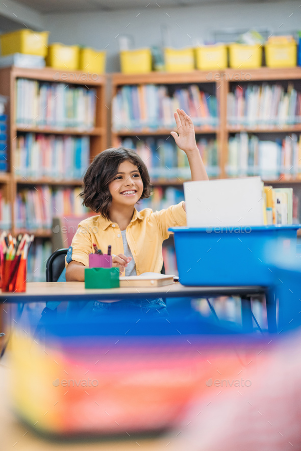 beautiful little girl raising hand on lesson at library Stock Photo by ...