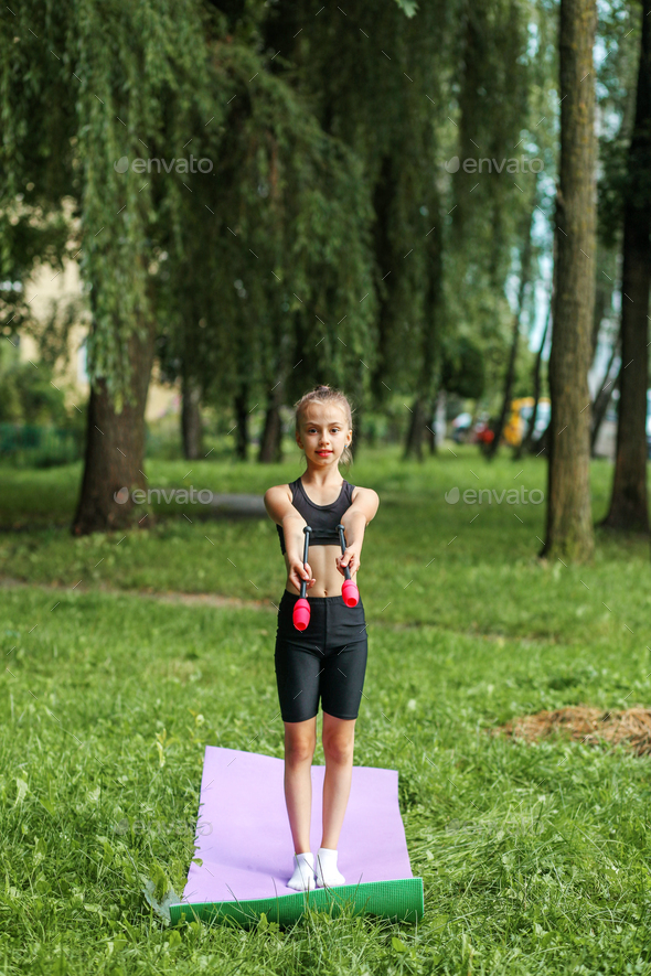 Rhythmic gymnastics. Preteen child exercising with gymnastic mace ...