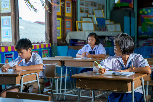 Elementary school kids sitting at desks in classroom,education,learning ...