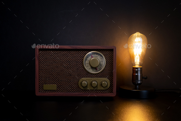 Vintage radio and light bulb on dark background. Stock Photo by Paulynn072