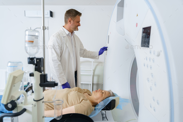 Doctor radiologist pushing button on panel to start mri scan procedure ...