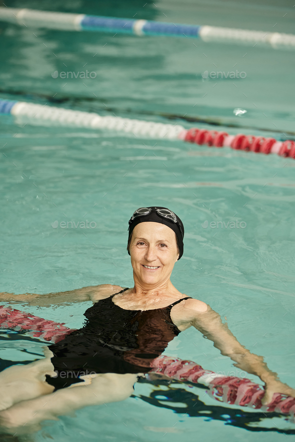 Cheerful And Fit Middle Aged Woman Swimming In Pool Swim Cap And
