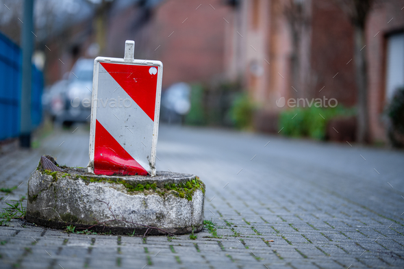 View of road construction sign with red and white lines on the street ...