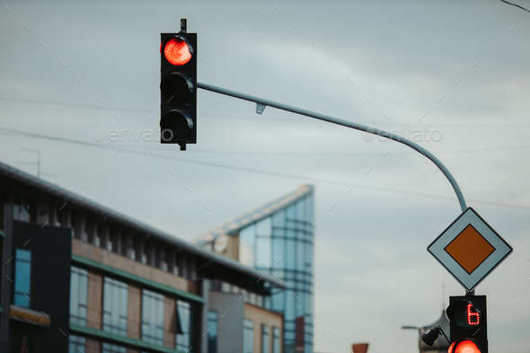 Main road sign and traffic light with a burning red signal for cars ...