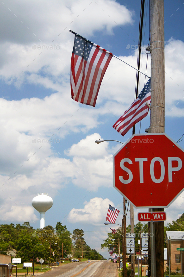 Stop Sign in Small Rural Town with American Flags and water tower Stock ...