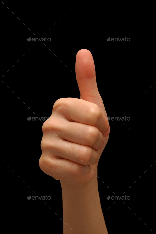 Closeup of a thumbs up hand signal isolated on a black background with ...