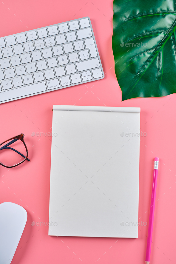 Vertical top view of a notepad, a pencil, glasses, and a keyboard on a ...