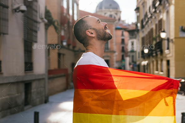 Radiant Man: Smiling under Sunset Glow, Holding LGBT Flag on Sunny City ...