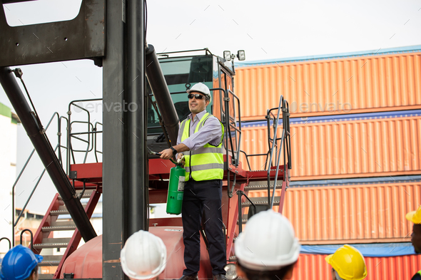 Manager training and showing staff worker to use fire extinguisher at ...