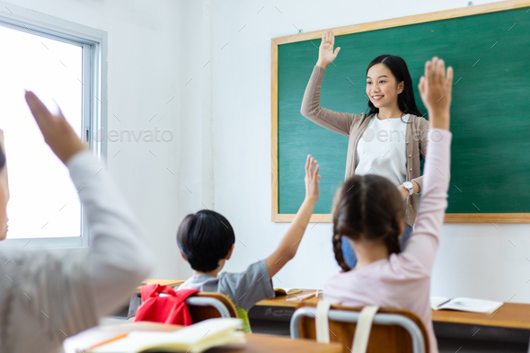 Diversity of school students raise their hands to answer teacher. Stock ...